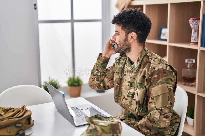 Young Arab Man Army Soldier Using Laptop Talking on the Smartphone at ...