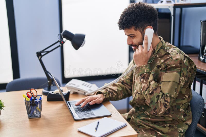 Young Arab Man Army Soldier Using Laptop Talking on the Telephone at ...