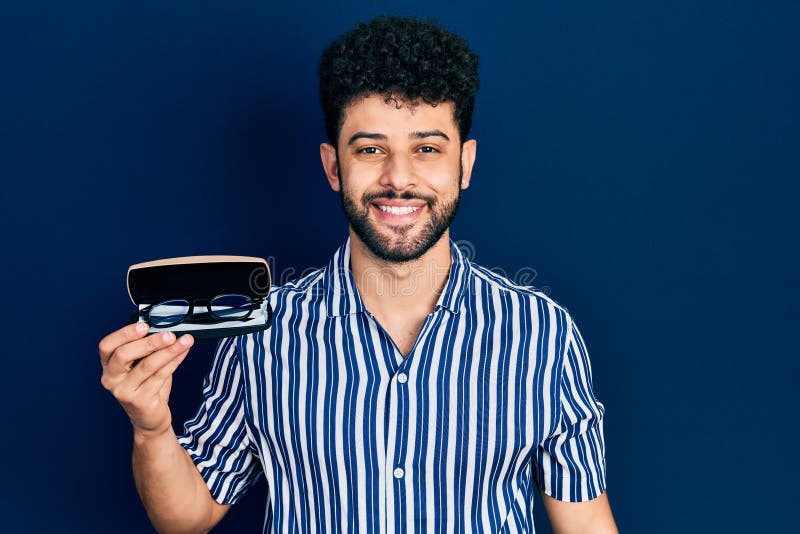Young Arab Man With Beard Holding Glasses In Eyewear Case Looking