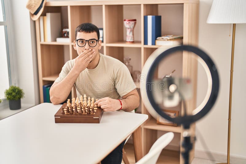 Young Arab Man Doing Chess Tutorial Covering Mouth with Hand, Shocked ...