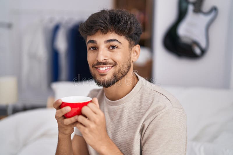 Young Arab Man Drinking Cup of Coffee Sitting on Bed at Bedroom Stock ...