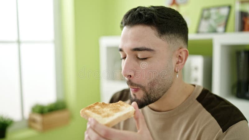 Young Arab Man Eating Toast Sitting on Table at Home Stock Video ...