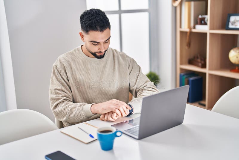 Young Arab Man Looking Watch Sitting on Table Working at Home Stock ...