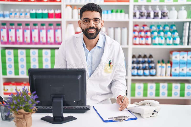 Young Arab Man Pharmacist Using Computer Writing on Document at ...
