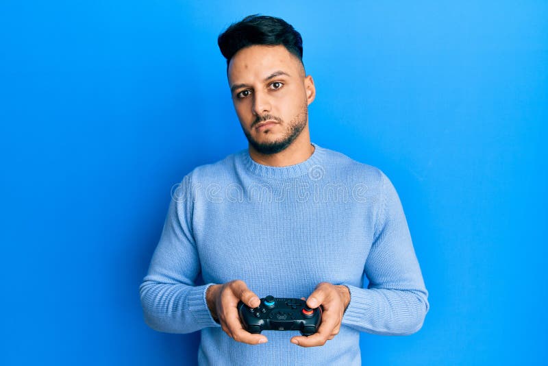 Young Arab Man Playing Video Game Holding Controller Clueless and ...
