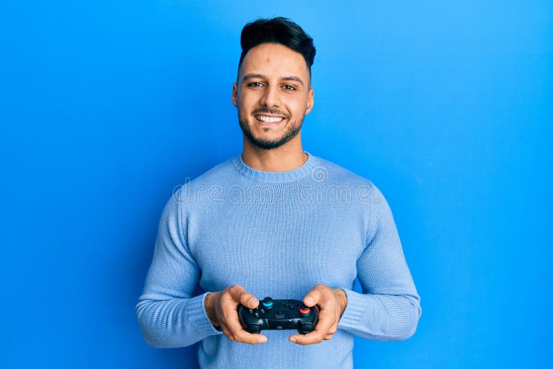 Young Arab Man Playing Video Game Holding Controller Smiling with a ...
