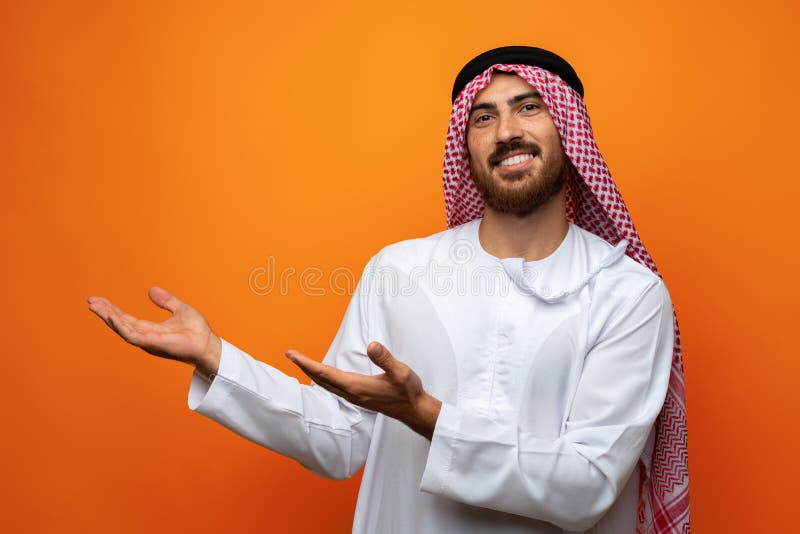 Young Arab Man Pointing Hand To Copy Space on Orange Background Stock ...