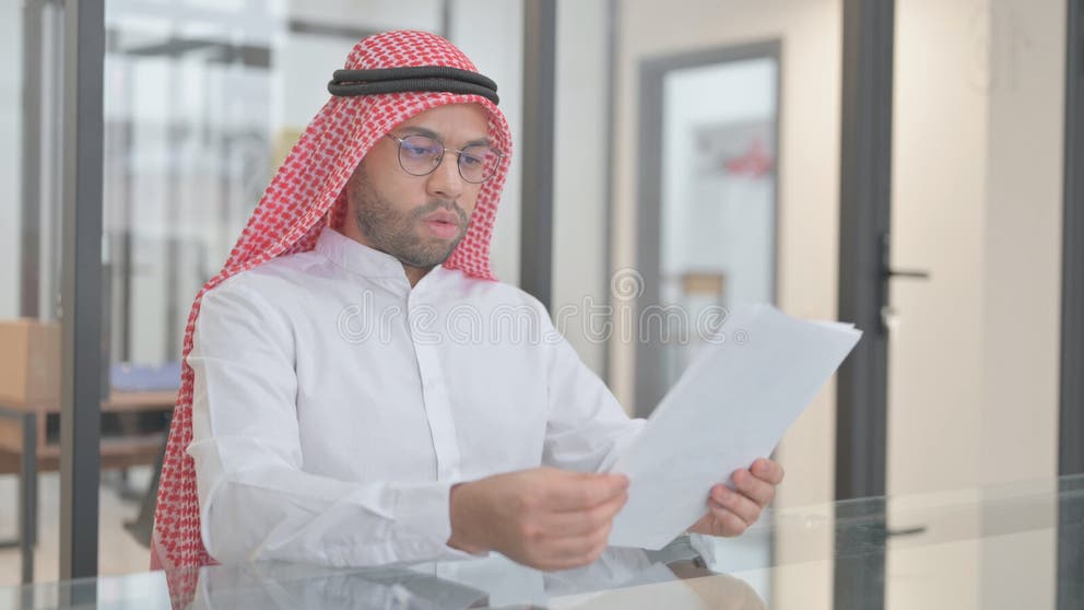Young Arab Man Reading Documents at Work Stock Image - Image of ...
