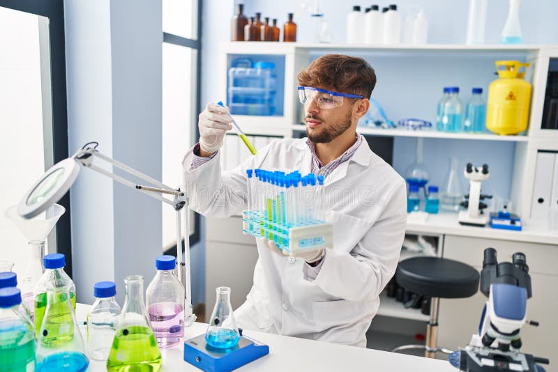 Young Arab Man Scientist Measuring Liquid Holding Test Tubes at ...