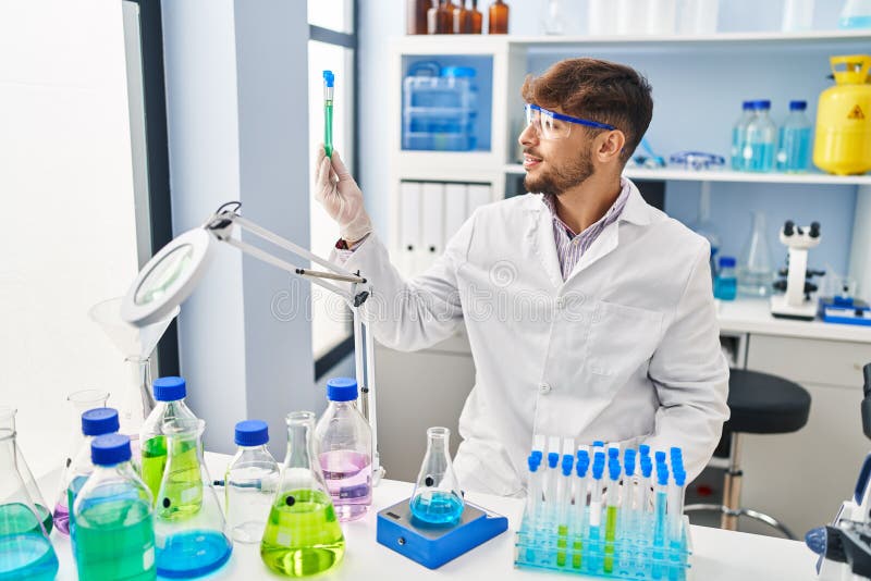 Young Arab Man Scientist Measuring Liquid Holding Test Tubes at ...