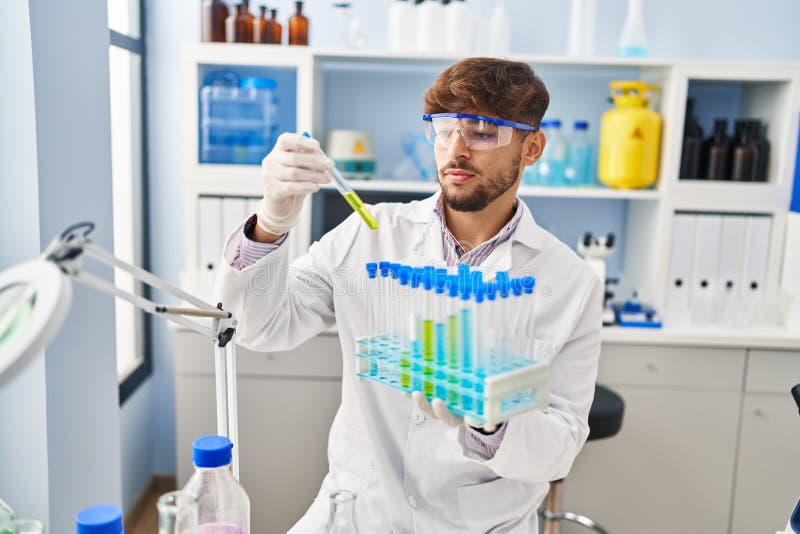 Young Arab Man Scientist Measuring Liquid Holding Test Tubes at ...