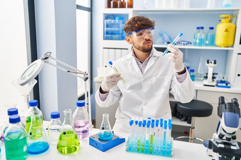 Young Arab Man Scientist Measuring Liquid Holding Test Tubes at ...