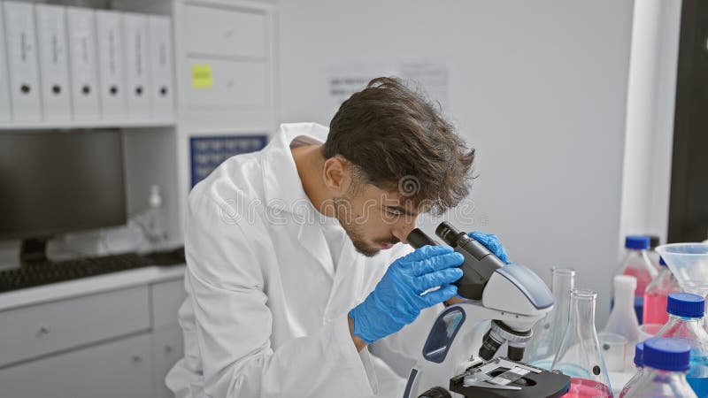 Young Arab Man Scientist Using Microscope at Laboratory Stock Photo ...