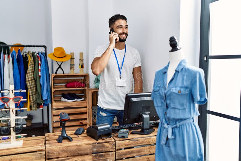 Young Arab Man Shopkeeper Talking on the Smartphone Working at Clothing ...