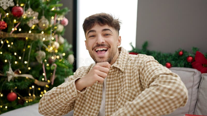 Young Arab Man Sitting by Christmas Tree Dancing at Home Stock Photo ...