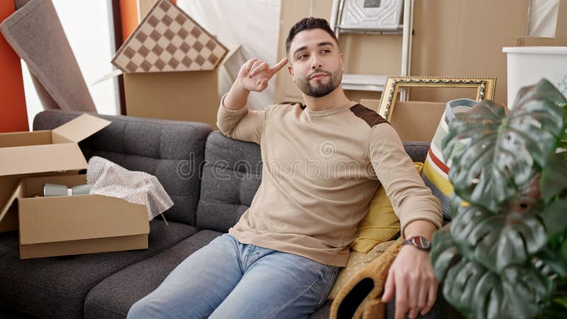 Young Arab Man Sitting on Sofa with Doubt Expression at New Home Stock ...