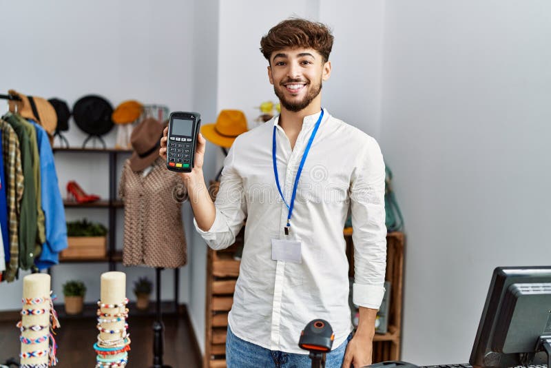 Young Arab Man Smiling Confident Holding Data Phone Device at Clothing ...