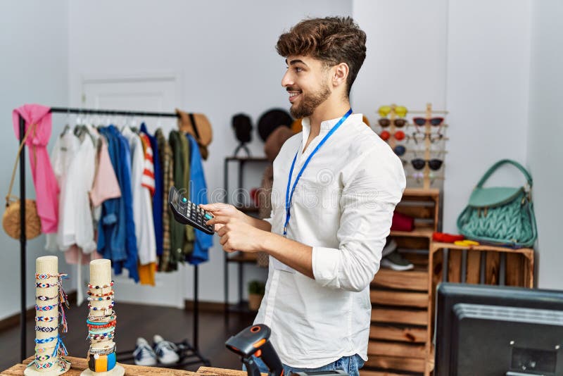 Young Arab Man Smiling Confident Using Calculator at Clothing Store ...