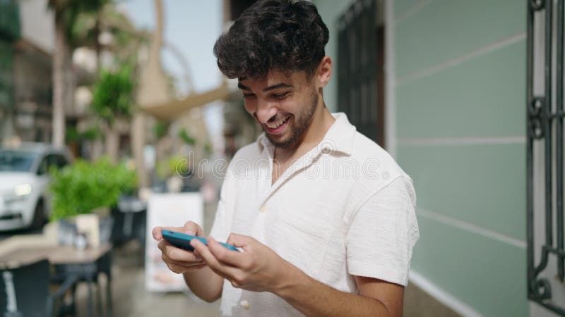 Young Arab Man Smiling Confident Watching Video on Smartphone at Street ...