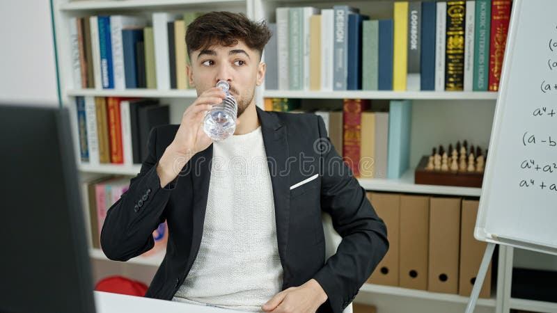 Young Arab Man Student Drinking Water at University Classroom Stock ...