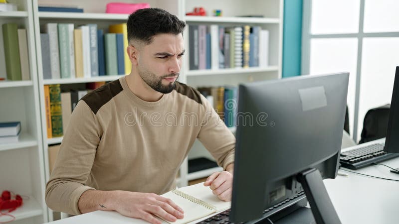 Young Arab Man Student Using Computer Studying with Doubt Expression at ...
