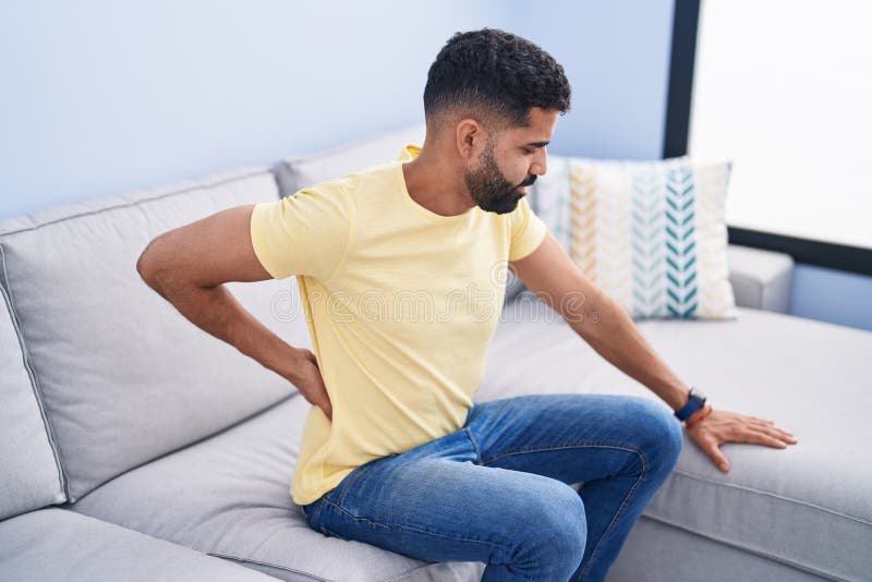 Young Arab Man Suffering for Backache Sitting on Sofa at Home Stock ...