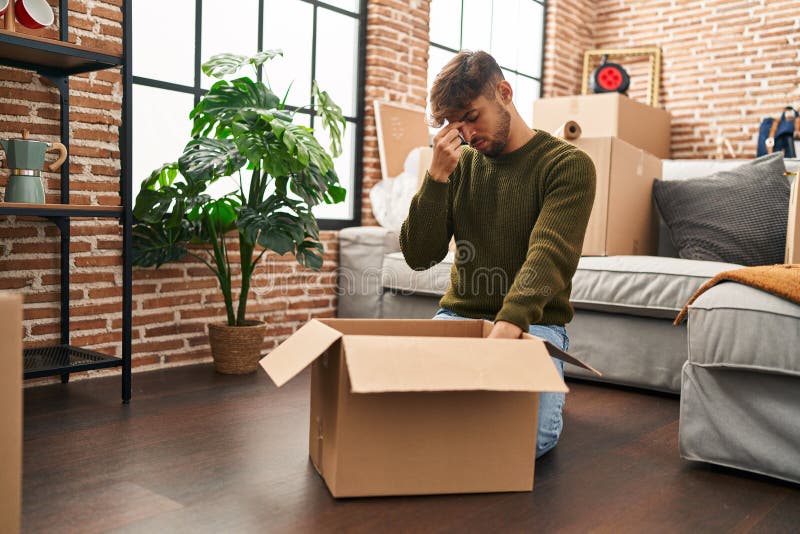 Young Arab Man Unboxing Cardboard Box with Worried Expression at New ...