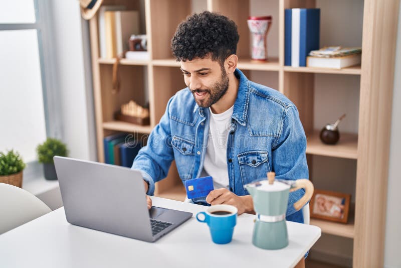 Young Arab Man Using Laptop and Credit Card Sitting on Table at Home ...