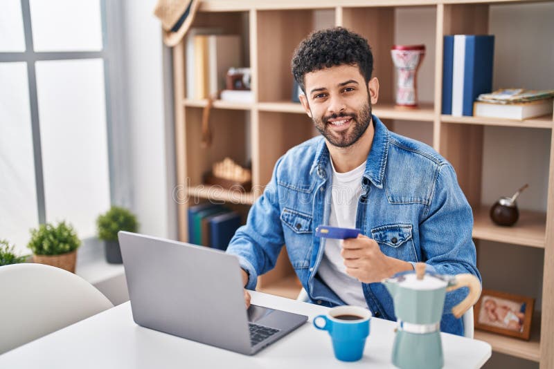 Young Arab Man Using Laptop and Credit Card Sitting on Table at Home ...
