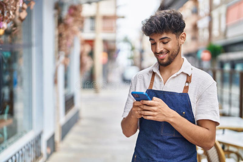 Young Arab Man Waiter Using Smartphone Working at Restaurant Stock ...