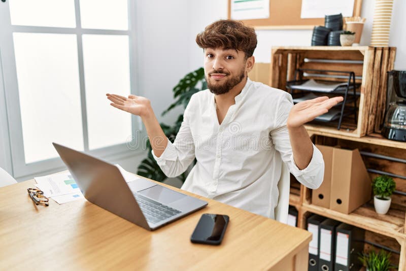 Young Arab Man Working Using Computer Laptop at the Office Clueless and ...