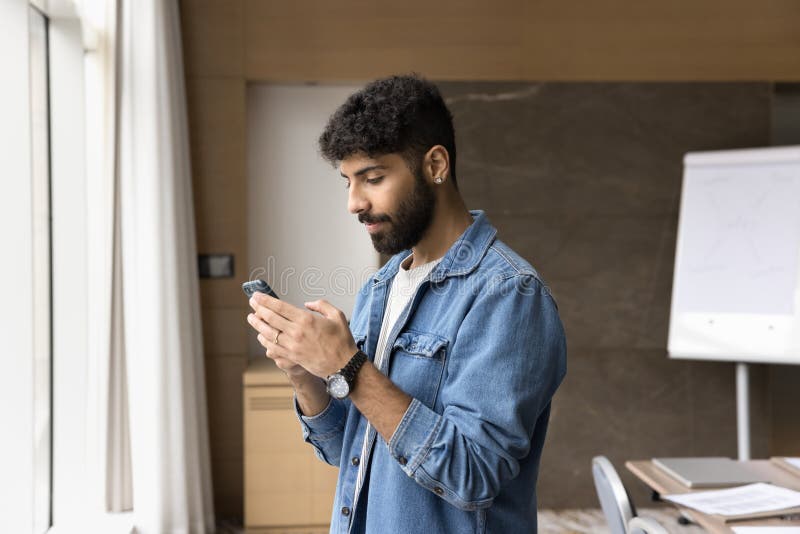 Young Male Office Employee Using Smartphone Standing in Modern ...