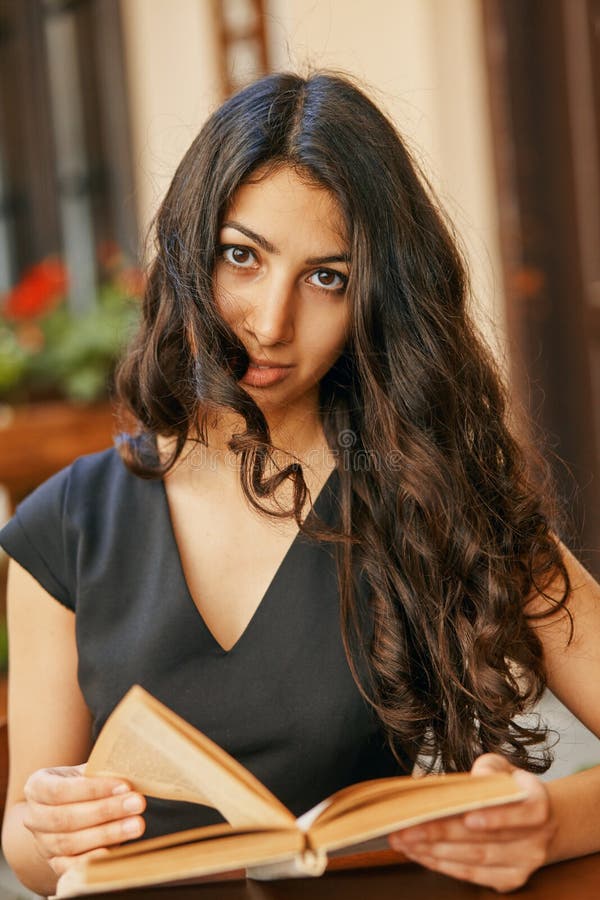 Young Arabic Woman Reading a Book in a Cafe Stock Photo - Image of ...