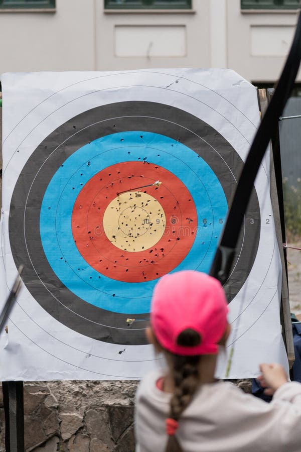 Archery Practice Target with Scattered Arrows and Young Archer in Pink ...