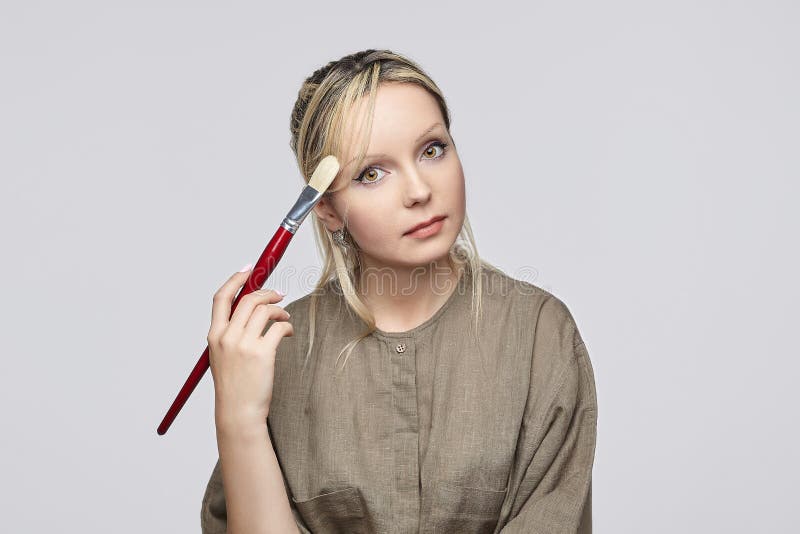 Young Artist Poses in Front of the Camera, Holding a Brush To Her Head ...