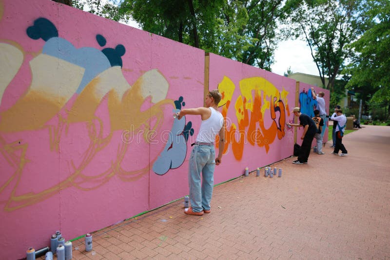 Young Artists Creating Colorful Graffiti Mural Outdoors. May 31, 2024 ...