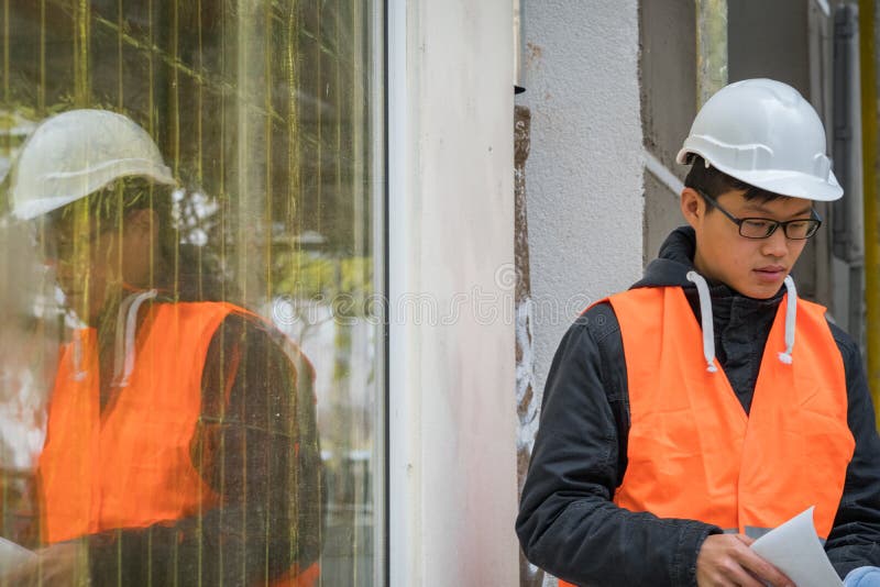 Asian Apprentice Engineer at Work on Construction Site with the Senior ...