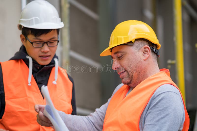 Asian Apprentice Engineer at Work on Construction Site with the Senior ...