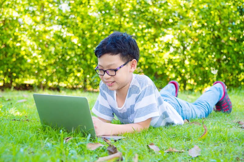 Boy Lying on Grass Field and Using Laptop Computer Stock Image - Image ...