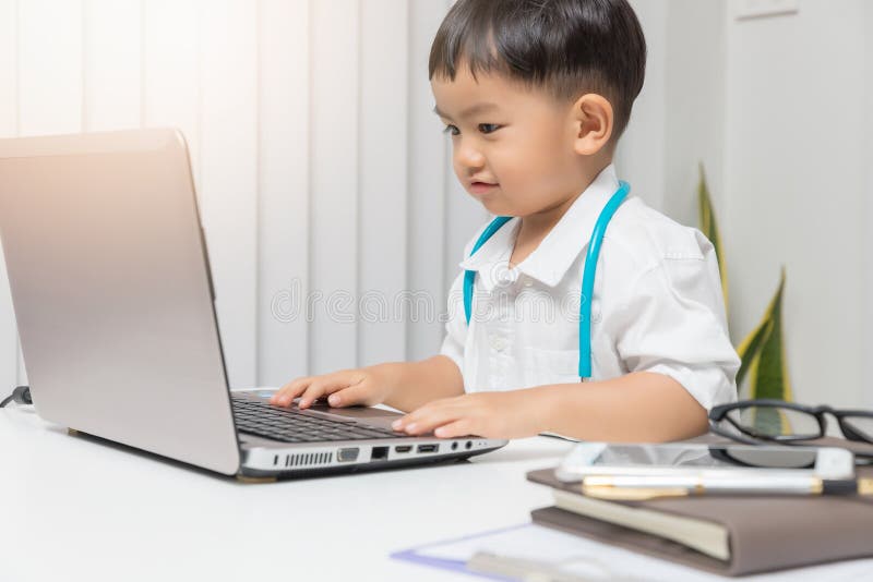 Young Asian Boy Playing Doctor and Using Computer Laptop Stock Photo ...