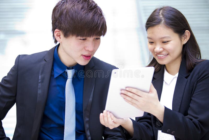Young Asian Business Executives Walking and Discussing Using Tablet PC ...