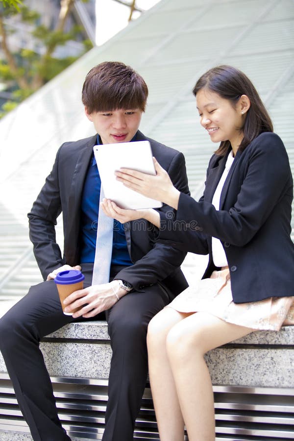 Young Asian Business Executives Walking and Discussing Using Tablet PC ...