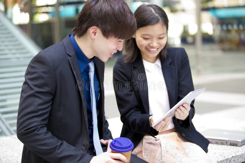 Young Asian Business Executives Walking and Discussing Using Tablet PC ...