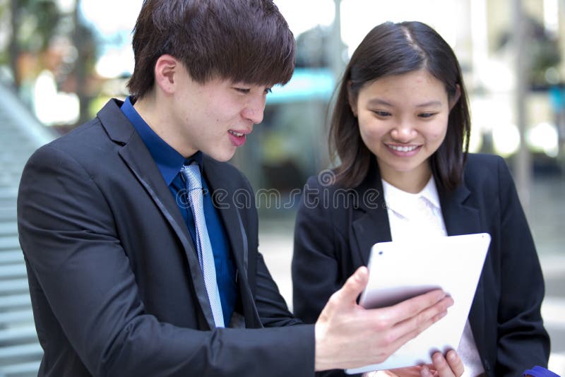 Young Asian Business Executives Walking and Discussing Using Tablet PC ...