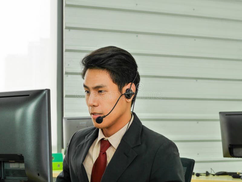 The Young Asian Business Man is a Customer Service Call Center Worker ...