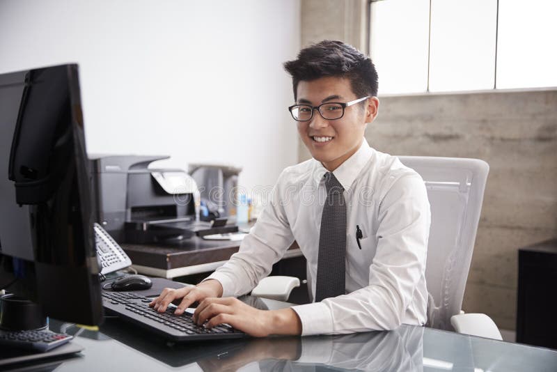 Young Asian Businessman Using a Computer, Smiling To Camera Stock Image ...