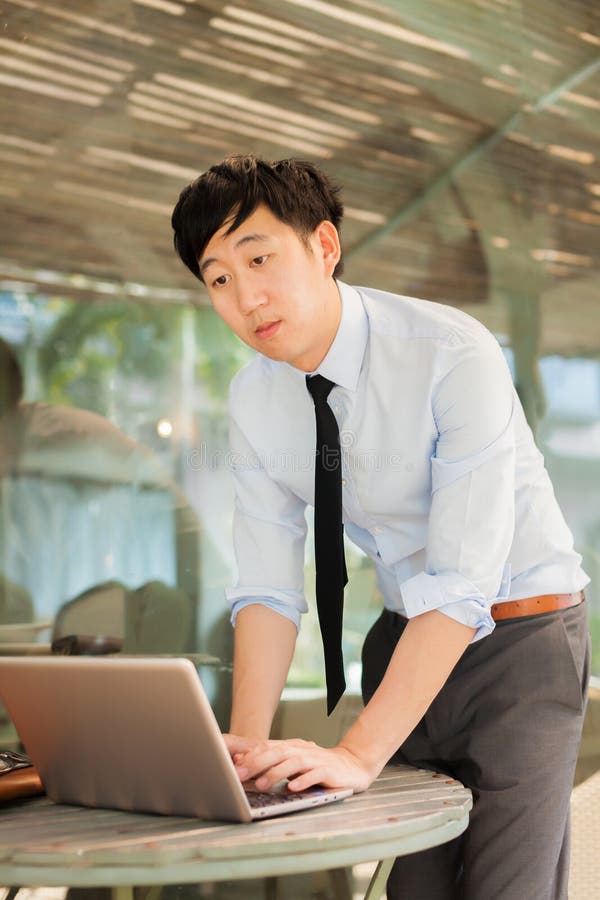 Young Asian Businessman Working on Computer while Standing in Outdoor ...