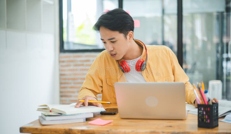 Young Asian College Student Working and Learning on Laptop in the Cafe ...