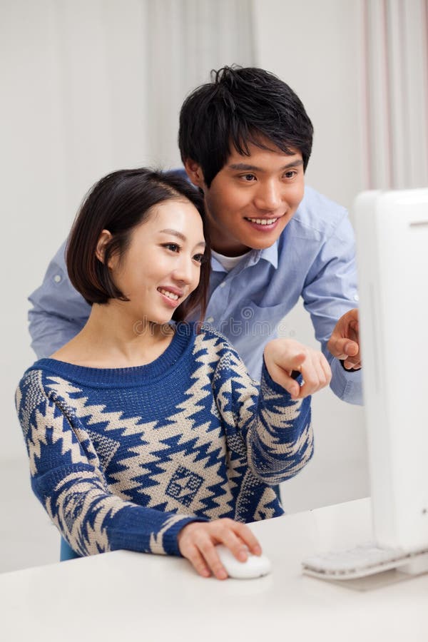 Young Chinese Couple Sitting Using Laptop at Home Stock Photo - Image ...
