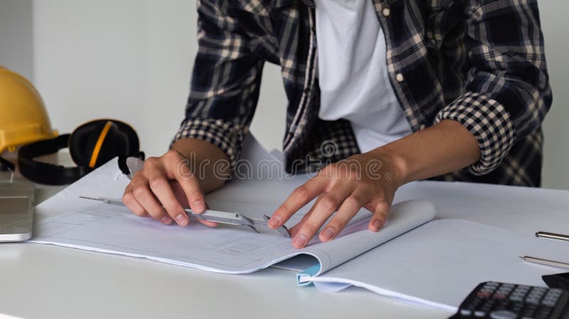 Young Asian Engineer Drawing Construction Project Plans on Plan Paper ...